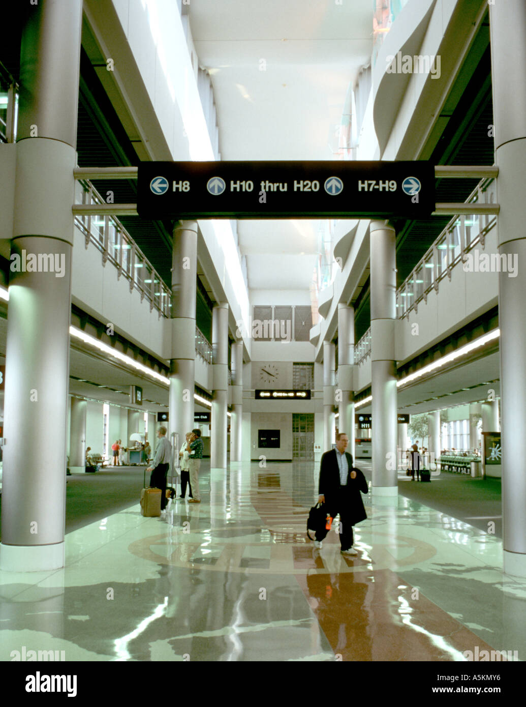 A male business traveler walks across the atrium in the Miami airport ...