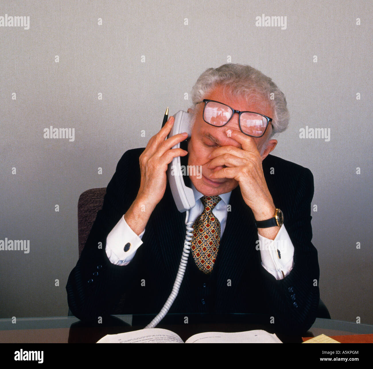 Elderly Man On the Phone in His Office Sitting At His Desk Concerned ...