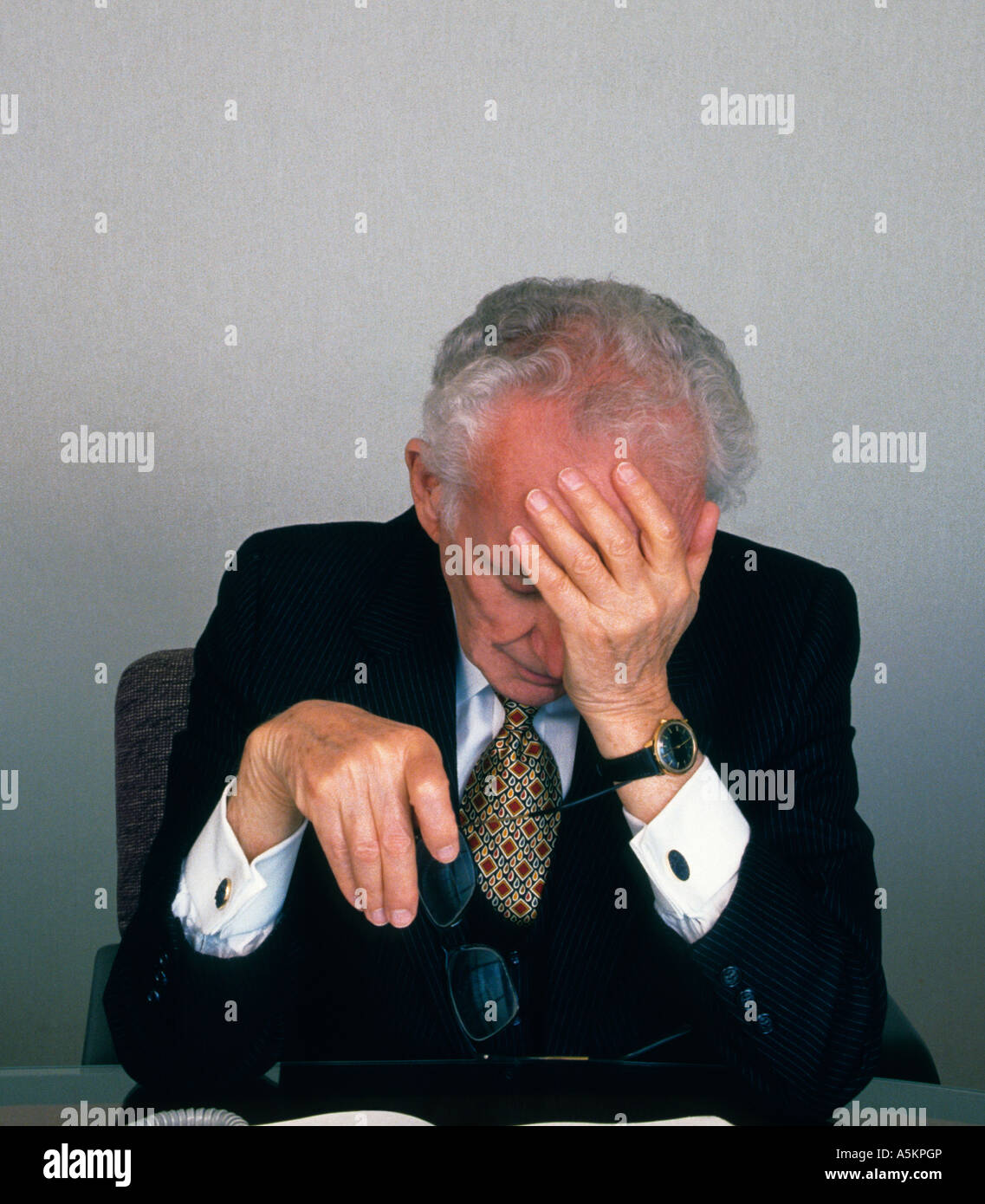 Elderly businessman wearing a suit in his office overworked and tired ...