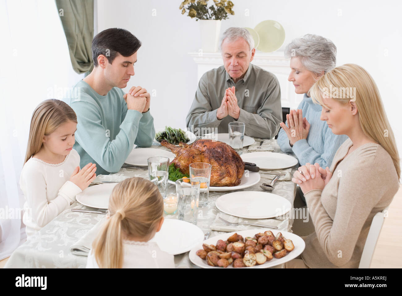 Family saying grace at Thanksgiving table Stock Photo - Alamy