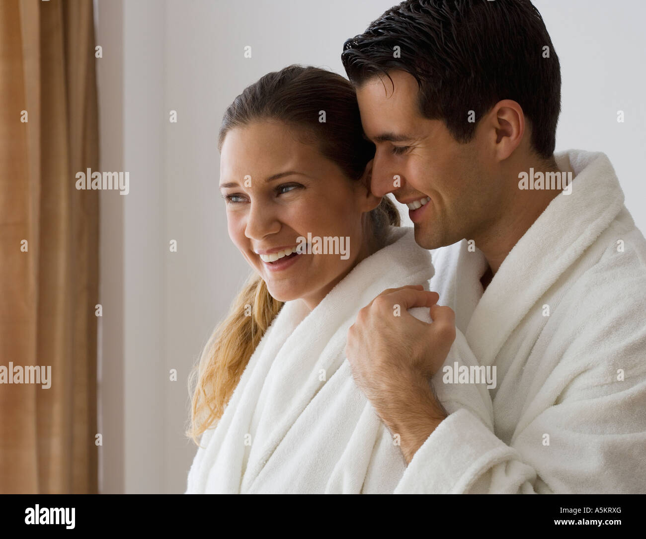 Couple in bathrobes hugging Stock Photo - Alamy