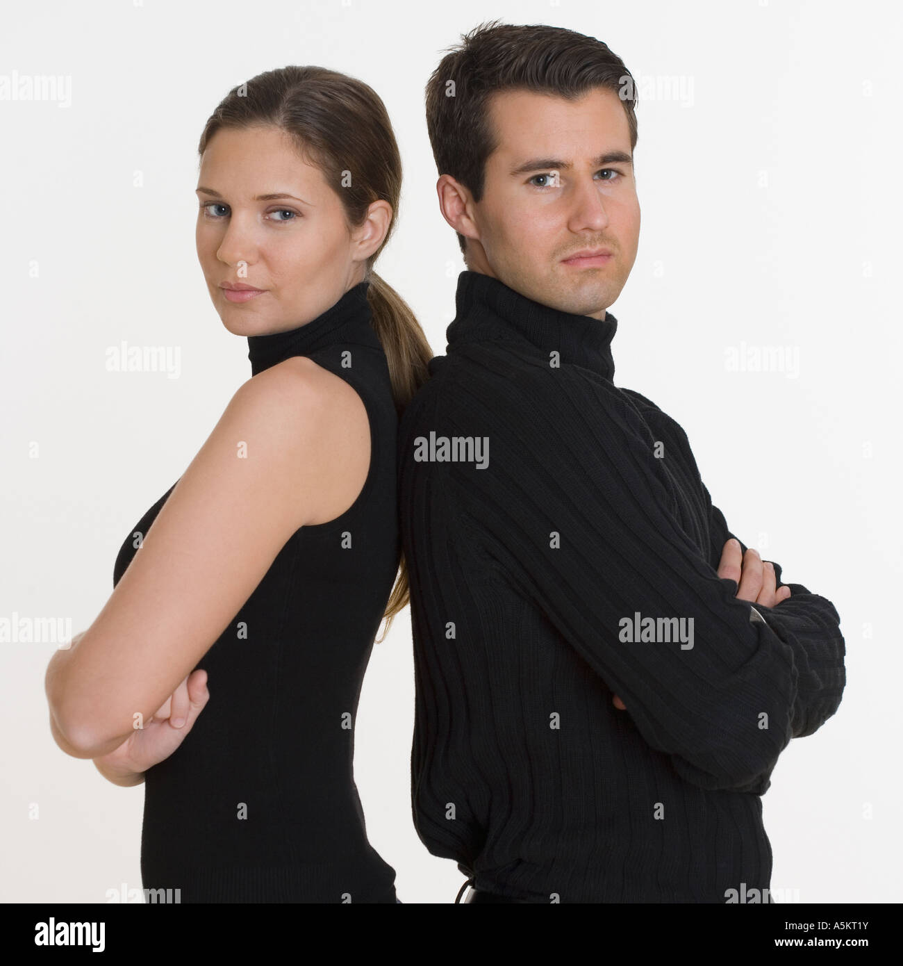 Studio shot of couple standing back to back Stock Photo - Alamy