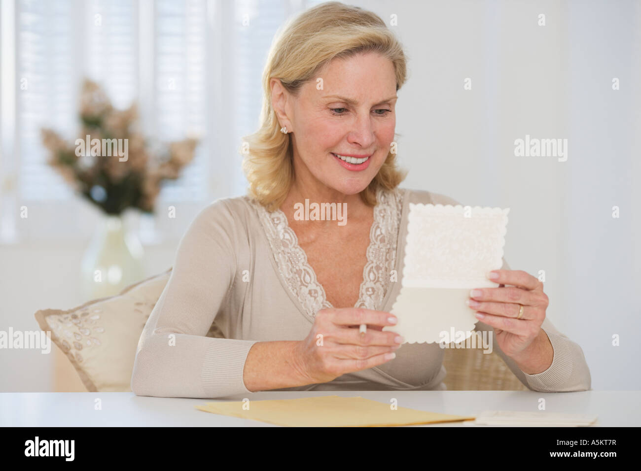 Senior woman reading card Stock Photo - Alamy