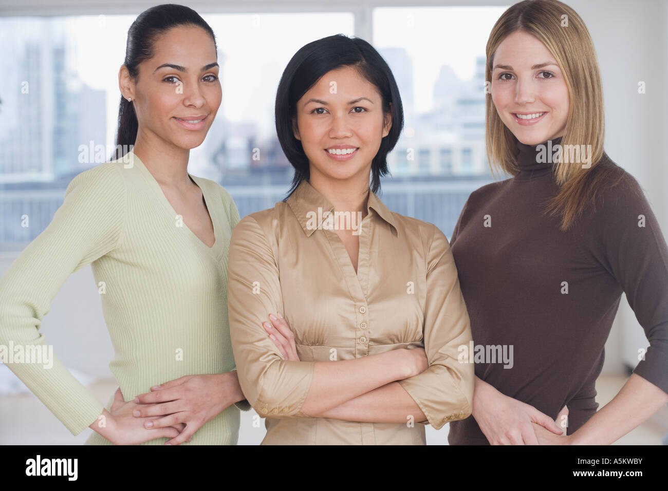Three women smiling indoors Stock Photo - Alamy