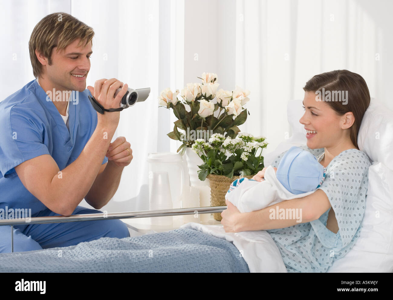 Father video recording mother and newborn baby Stock Photo - Alamy
