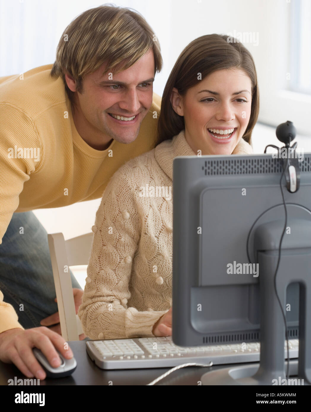 Couple smiling at webcam on computer Stock Photo - Alamy