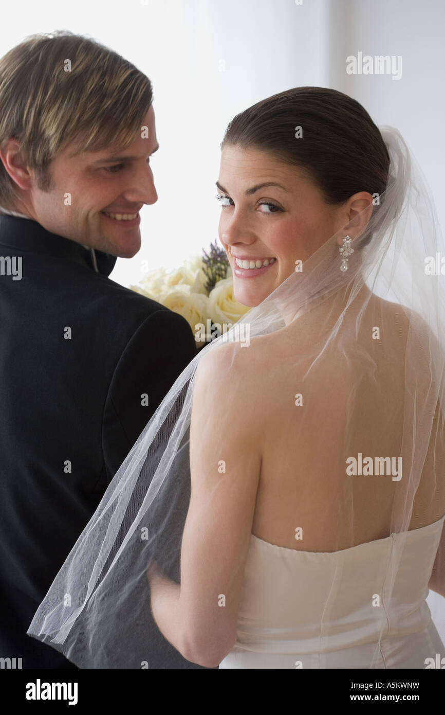 Portrait of bride and groom looking over shoulders Stock Photo - Alamy