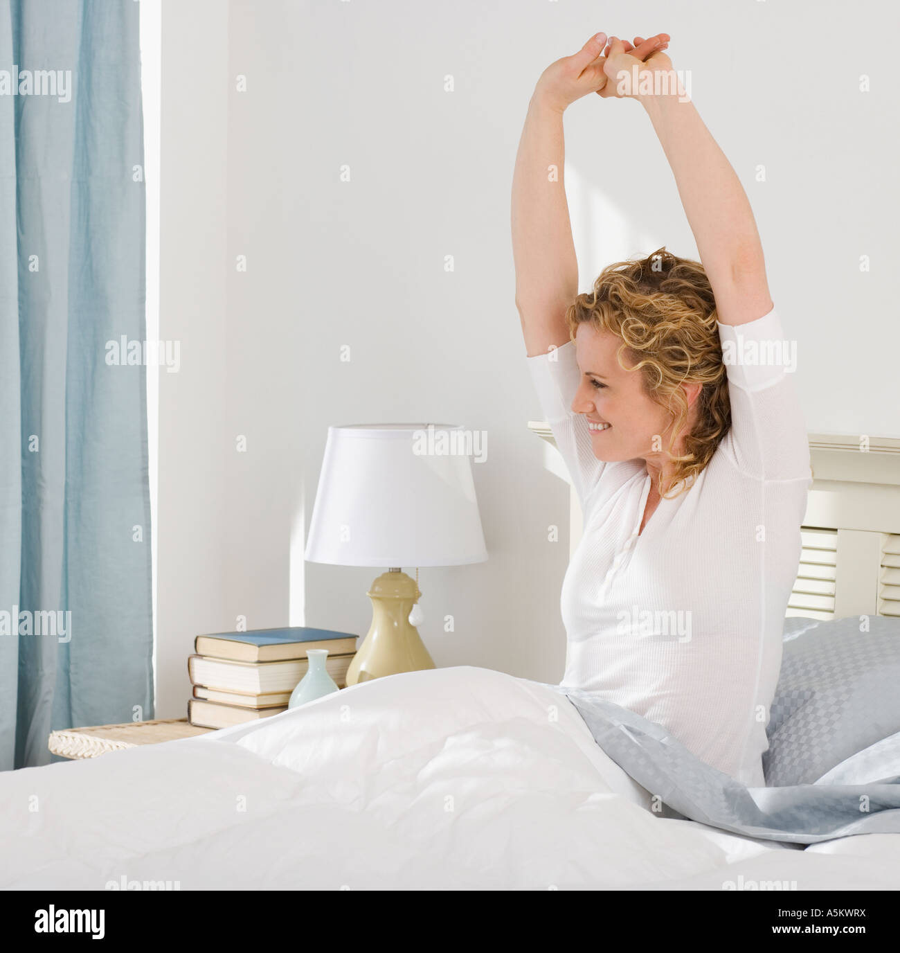 Woman stretching in bed Stock Photo - Alamy