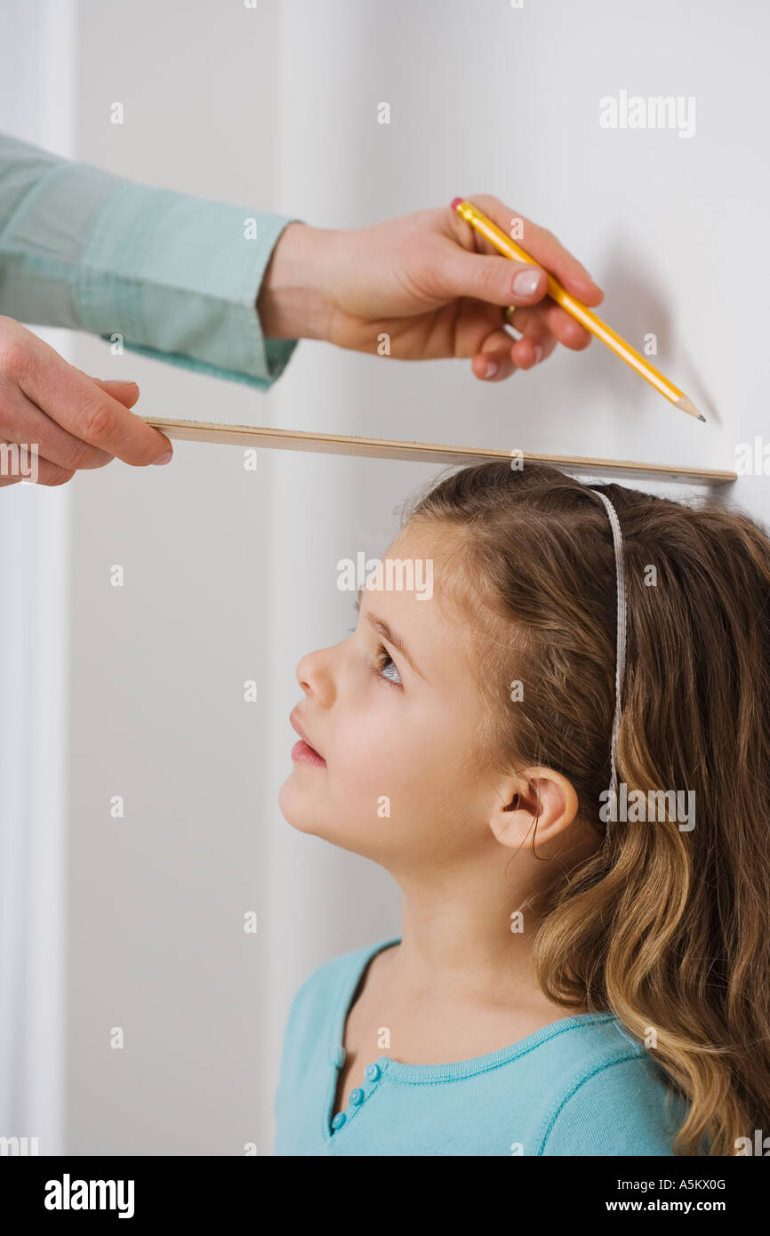 Mother marking daughter s height on wall Stock Photo - Alamy