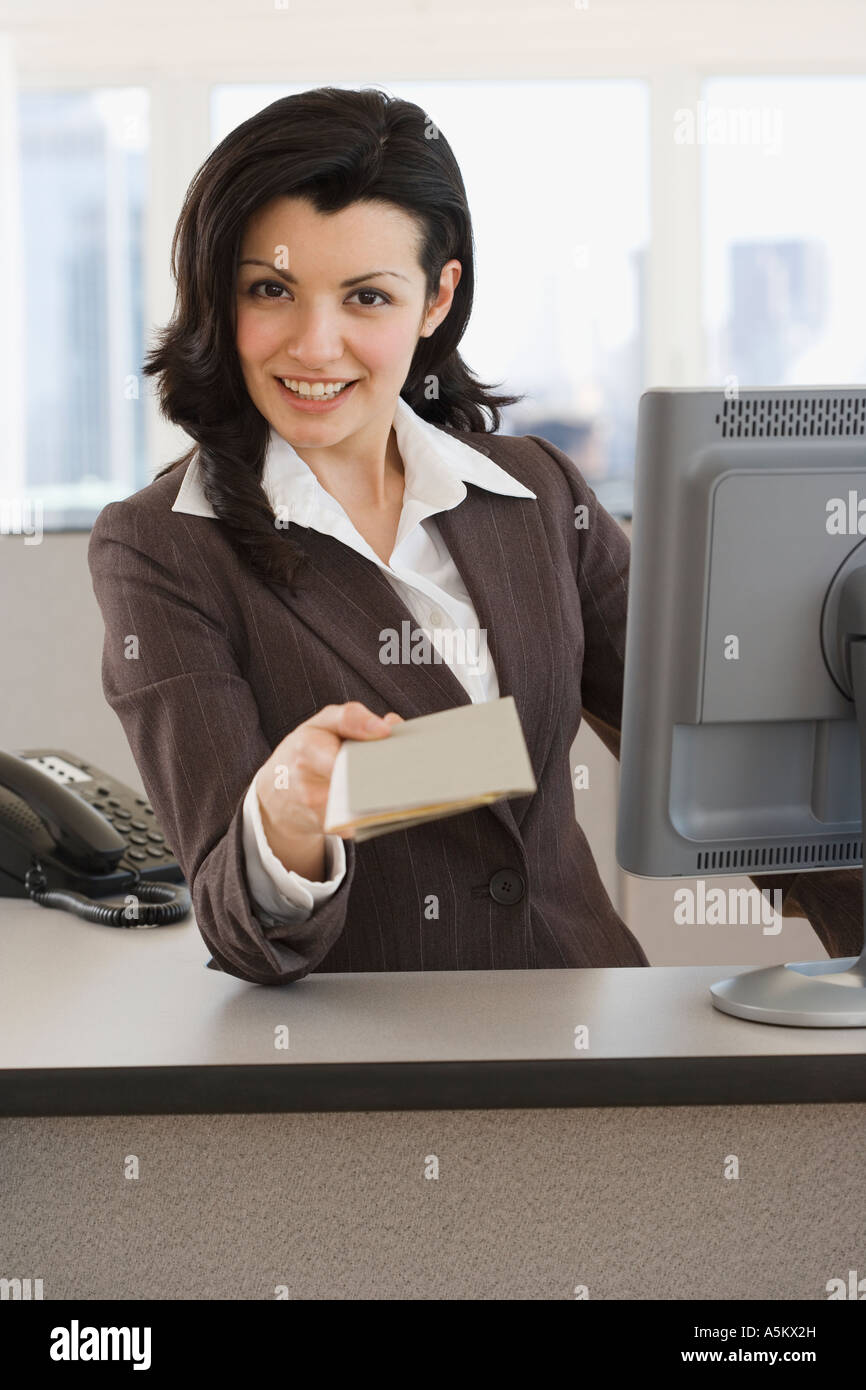Woman handing paperwork over counter Stock Photo - Alamy