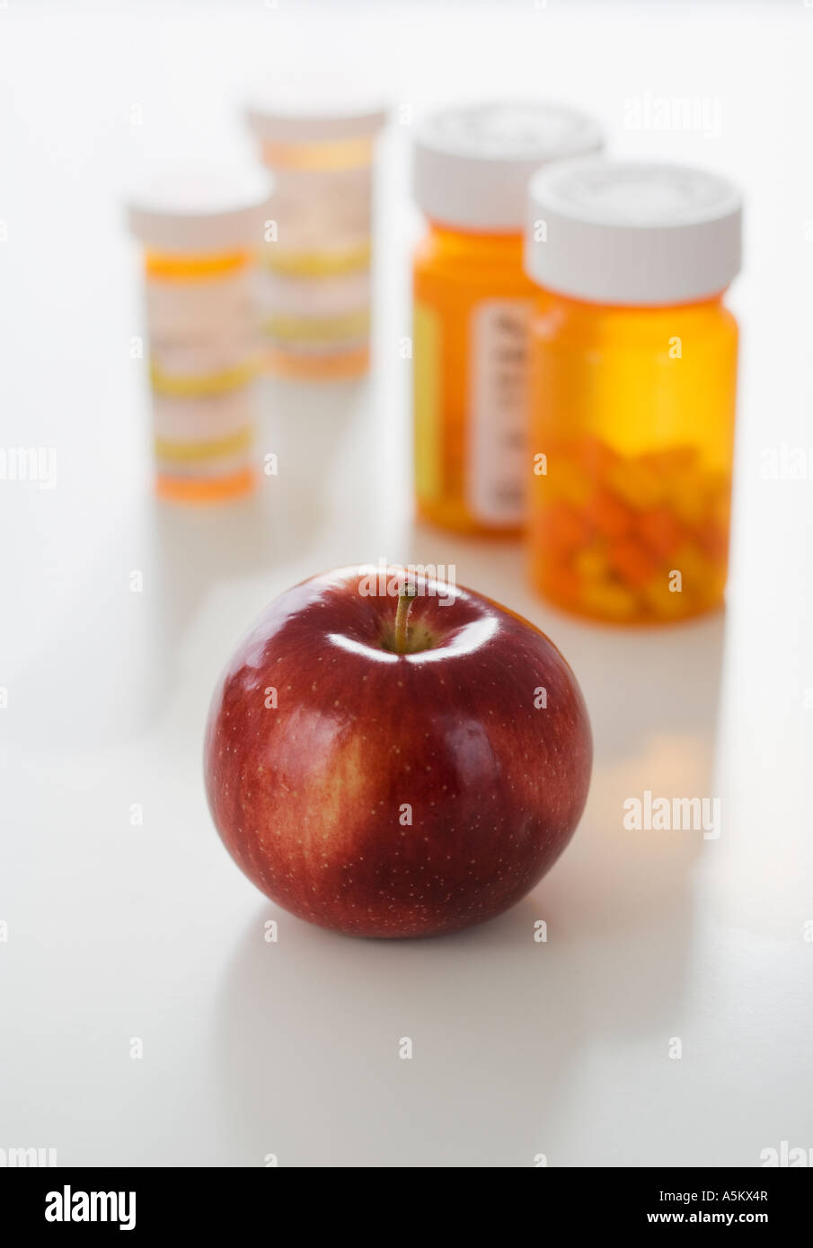 Apple in front of medication bottles Stock Photo - Alamy