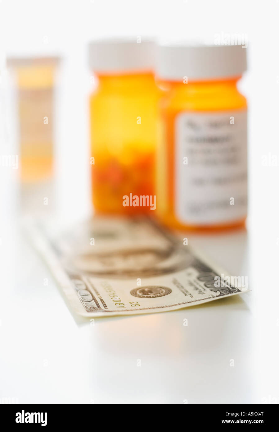 Money in front of medication bottles Stock Photo - Alamy