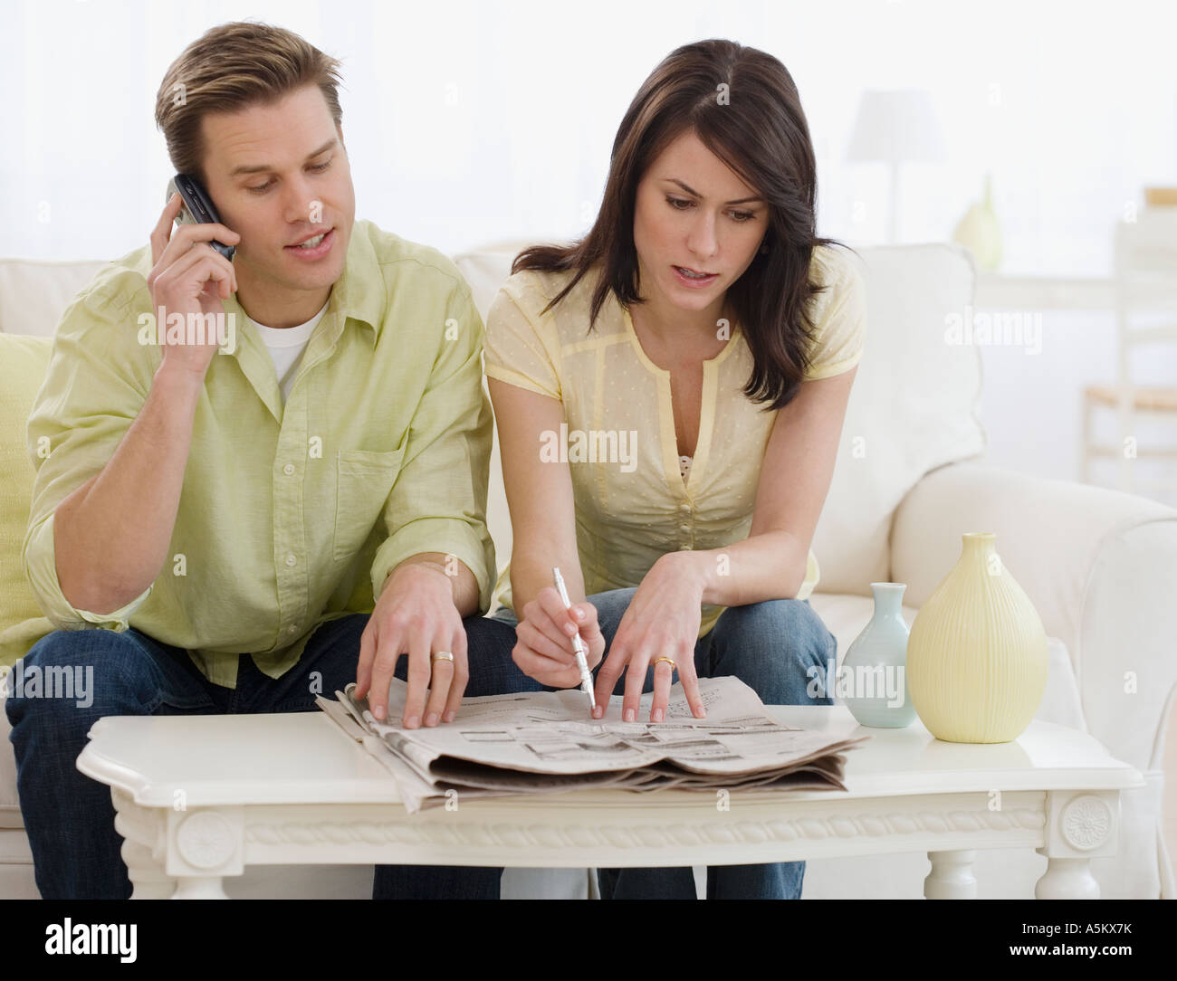 Couple reading classifieds in newspaper Stock Photo - Alamy