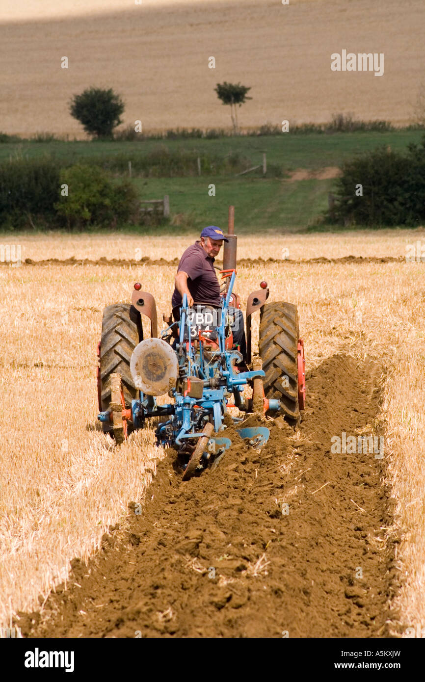 Man ploughing on old tractor Stock Photo - Alamy