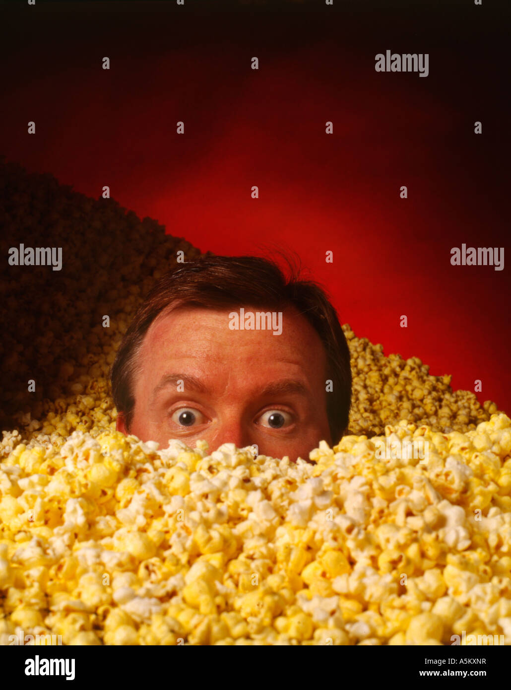 Up to the eyeballs in popcorn Stock Photo - Alamy