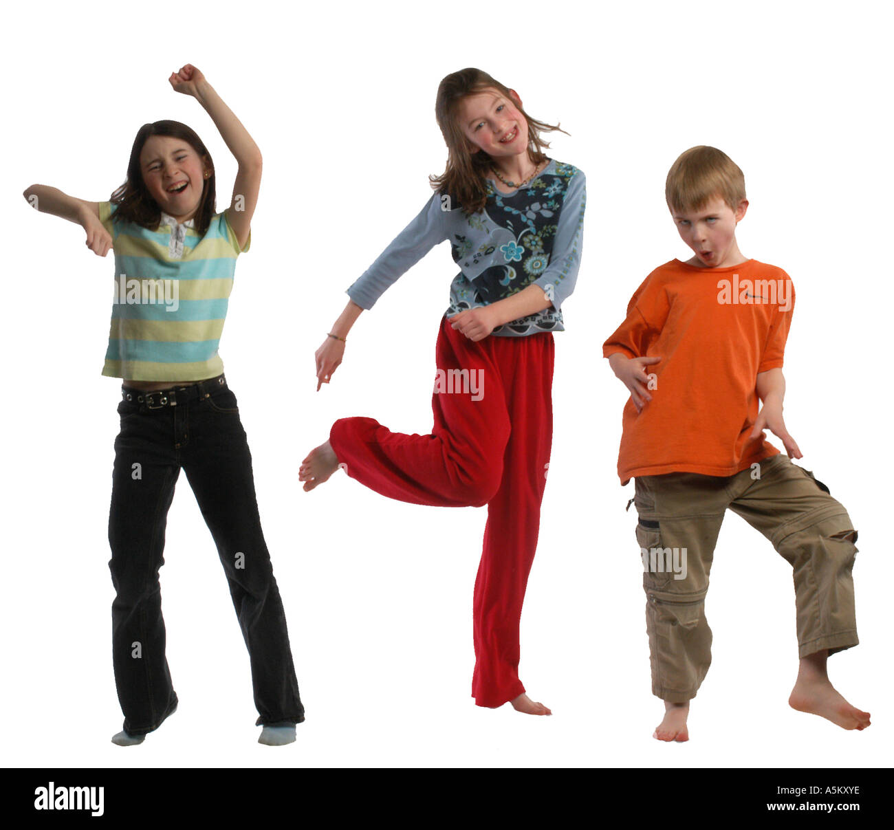 Three young children are dancing and laughing together and are ...