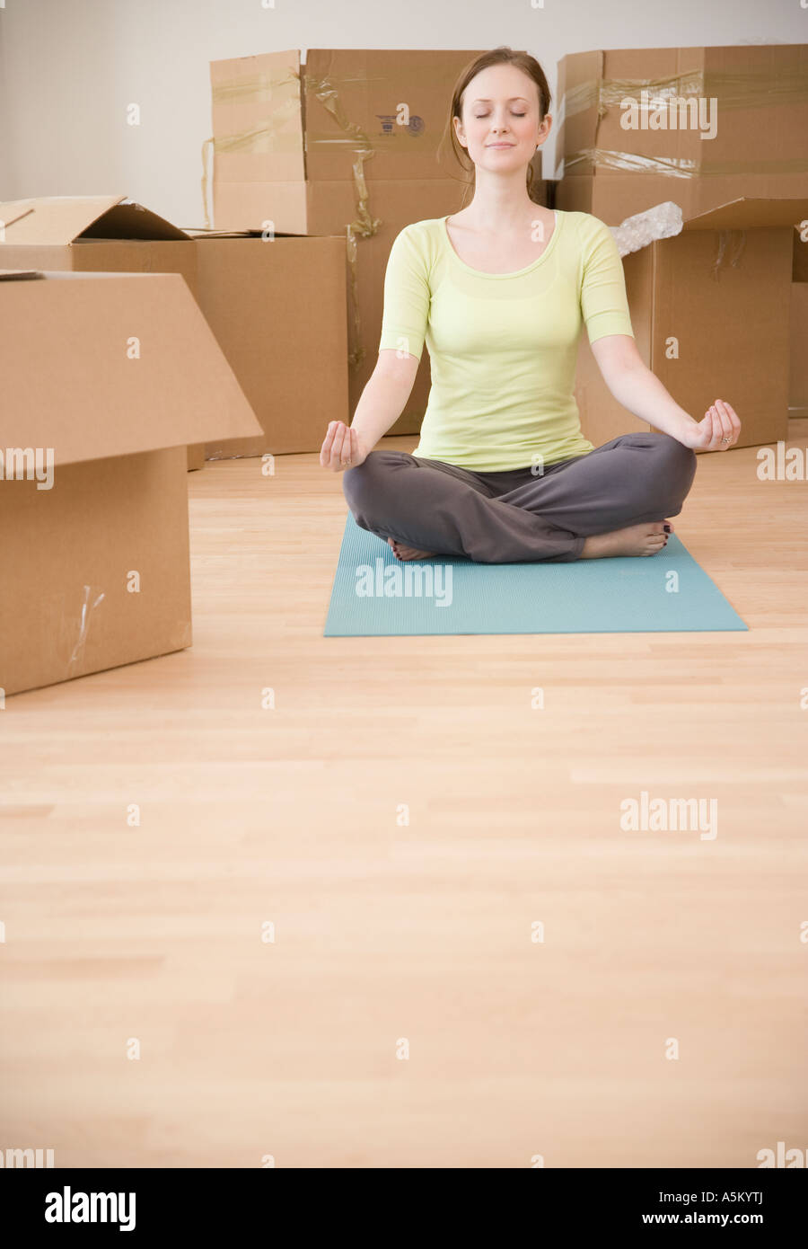 Woman meditating in new house Stock Photo - Alamy