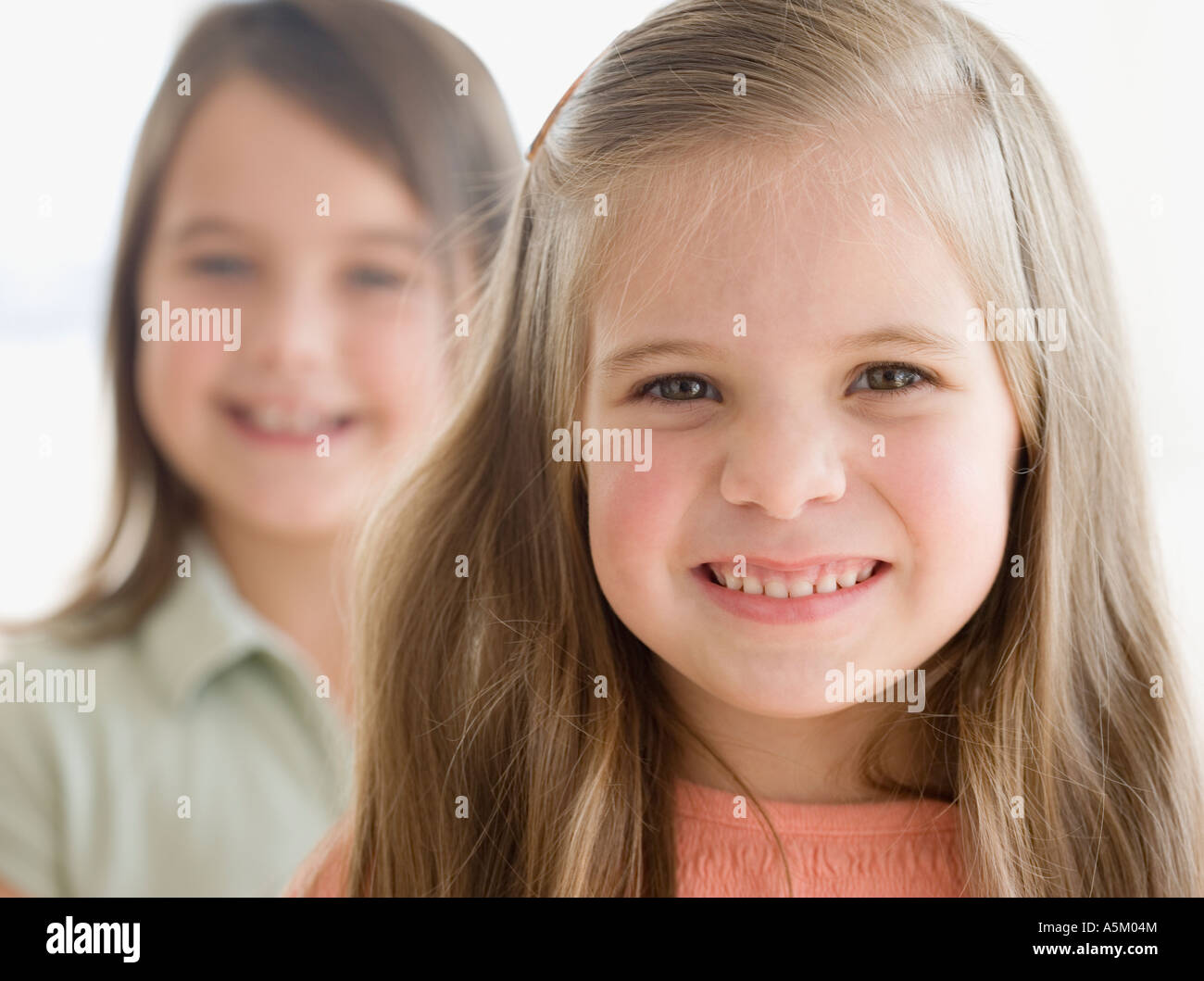 Girl smiling with sister in background Stock Photo - Alamy