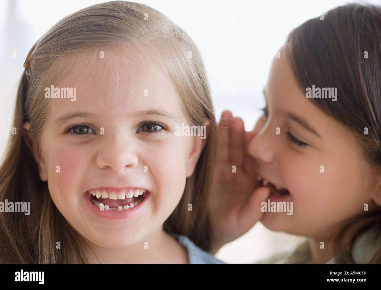 Close up of sisters telling secret Stock Photo - Alamy