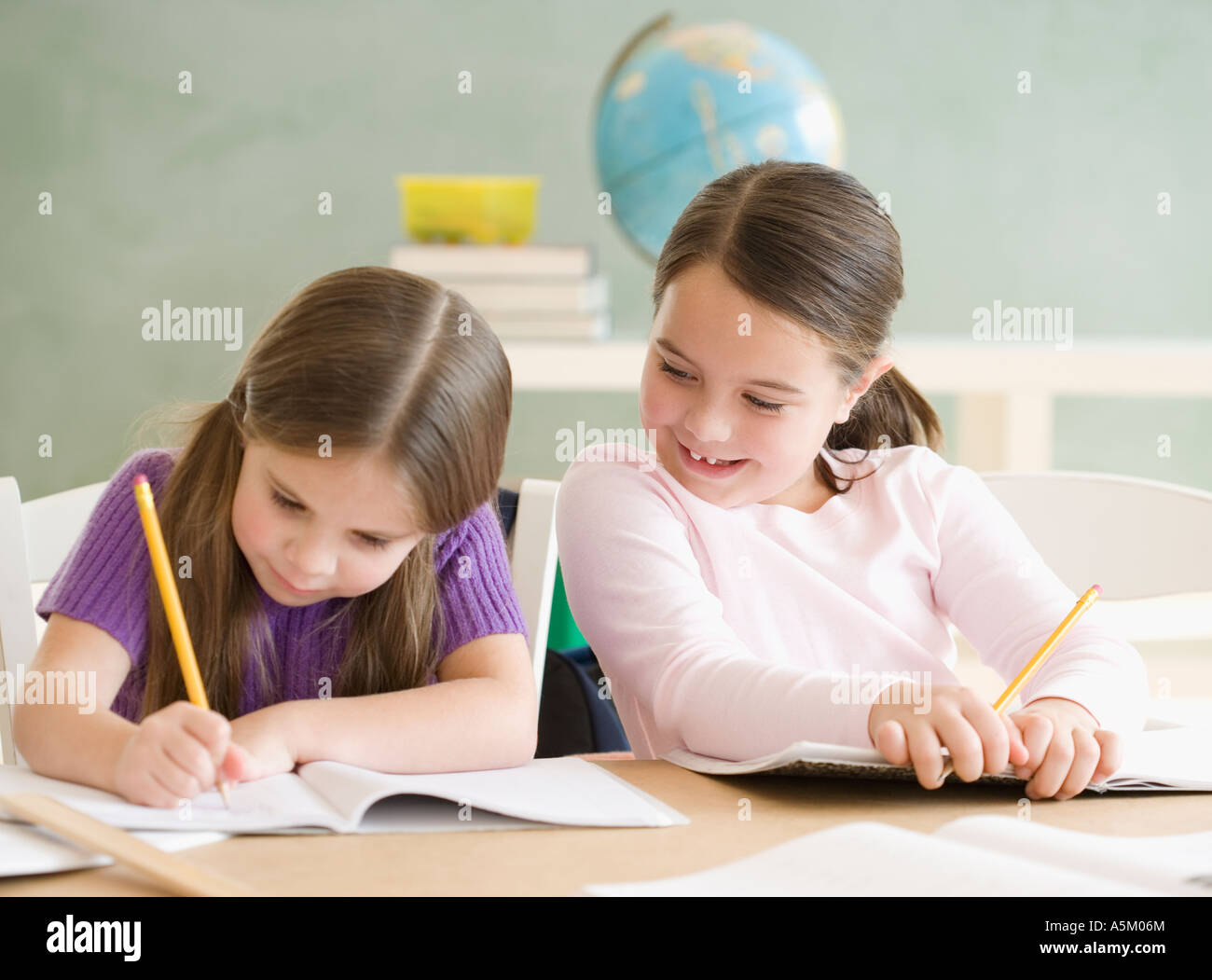 Two girls studying in classroom Stock Photo - Alamy