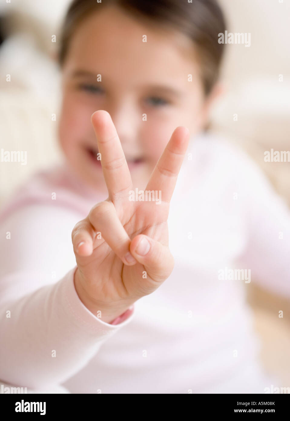 Girl holding up two fingers Stock Photo - Alamy