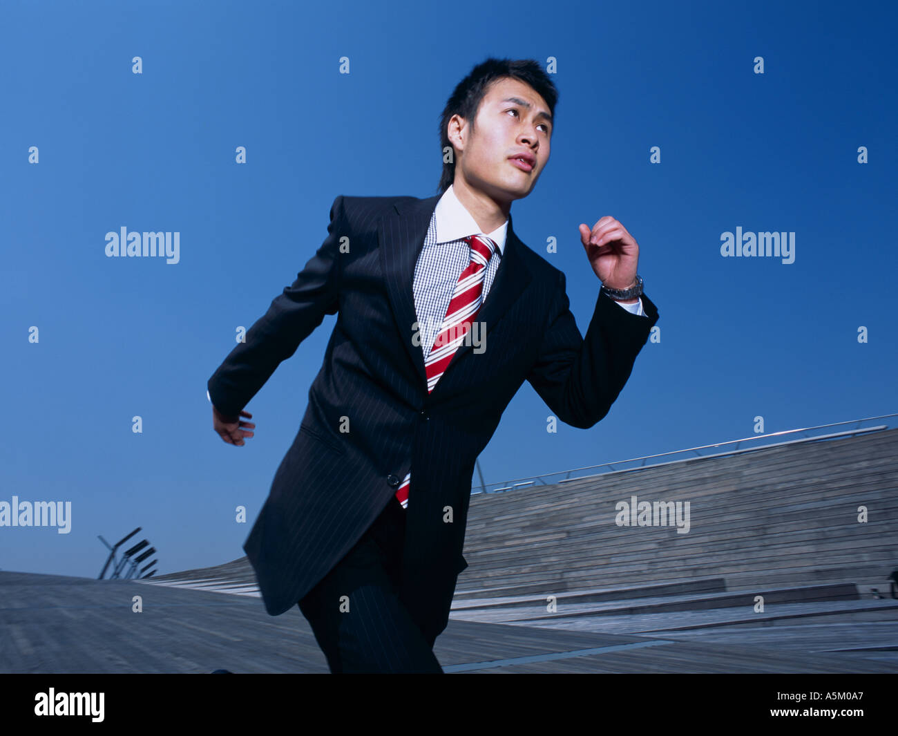 Asian Man running down a bridge Stock Photo - Alamy