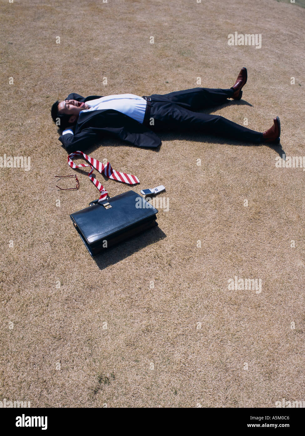 Asian Businessman lying flat on the ground Stock Photo - Alamy