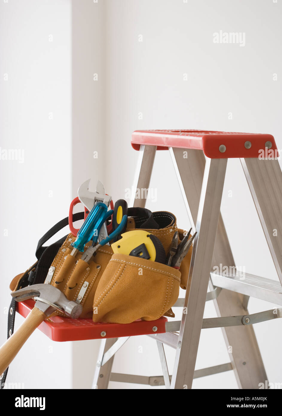 Tool belt on ladder shelf Stock Photo - Alamy