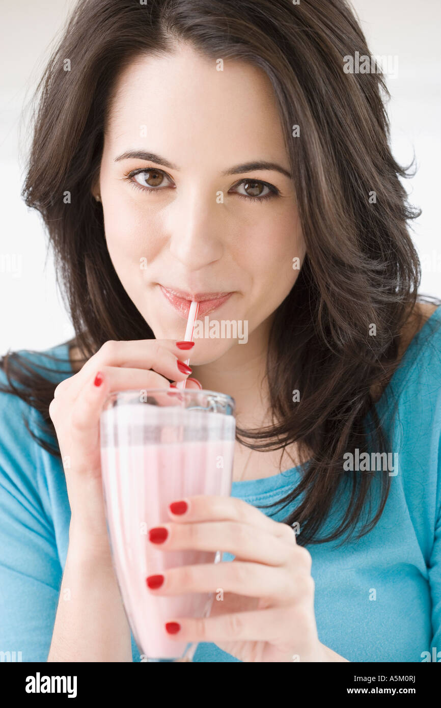 Woman drinking milkshake with straw Stock Photo - Alamy
