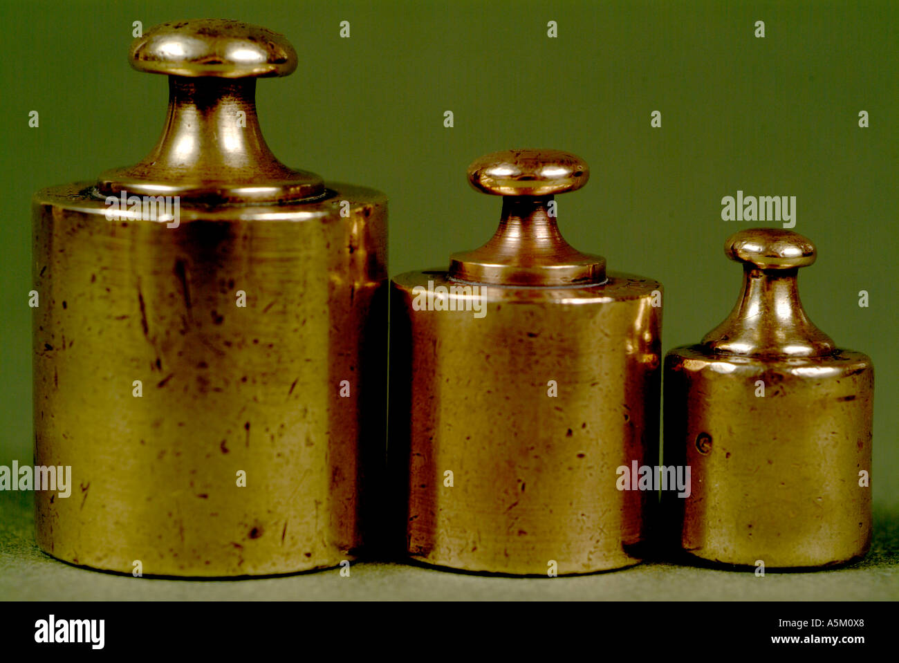Three french copper scale weights aligned Stock Photo - Alamy