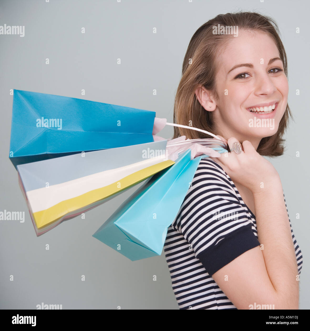 Teenage girl holding shopping bags over shoulder Stock Photo - Alamy