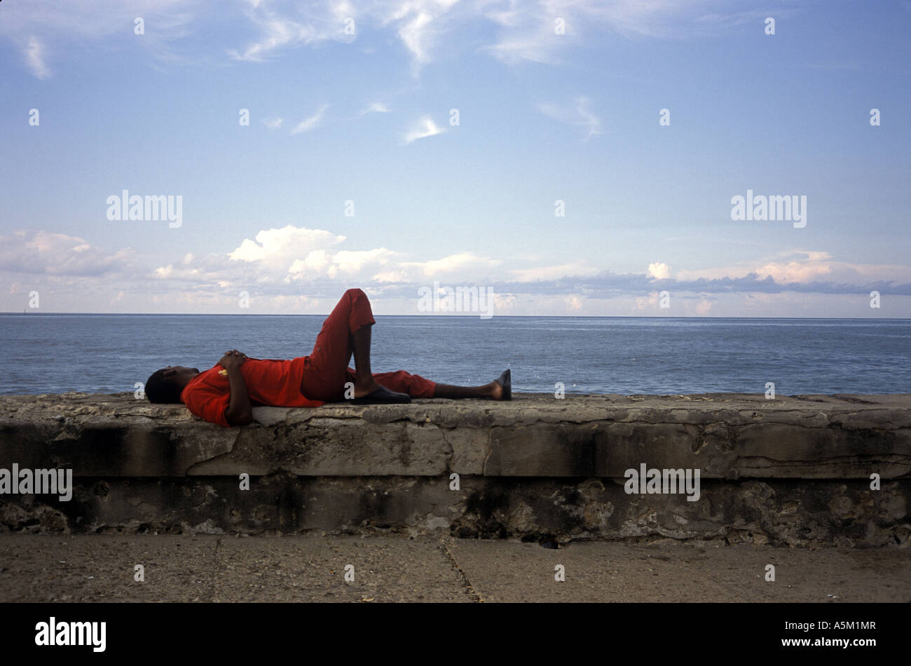 A Cuban man rests on Havana's famed Malecon sea wall Stock Photo - Alamy
