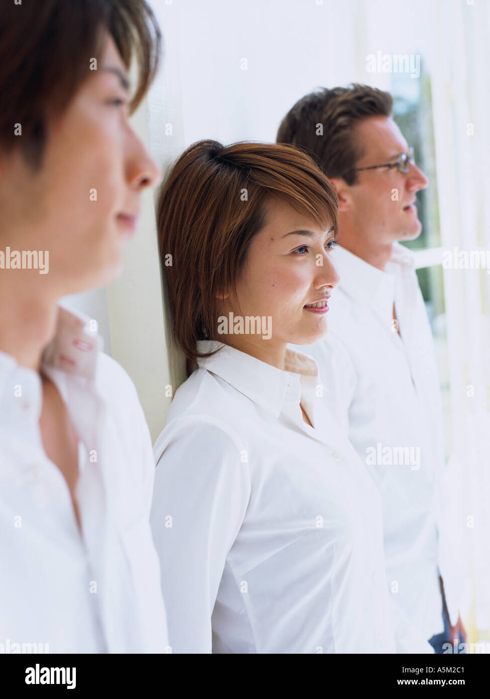 People standing against a wall Stock Photo - Alamy