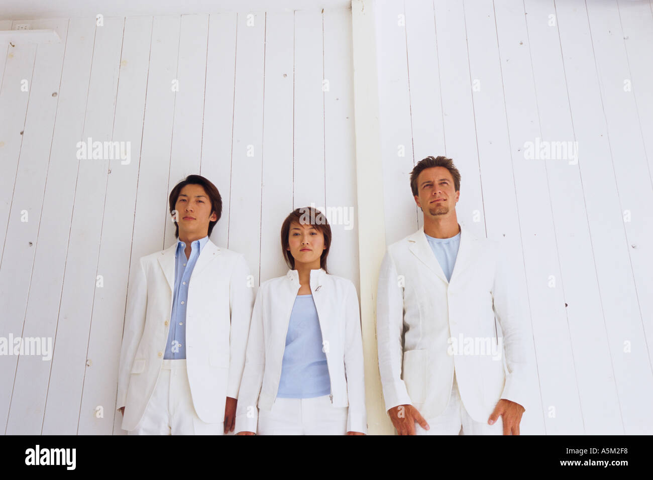 People standing against a wall Stock Photo - Alamy