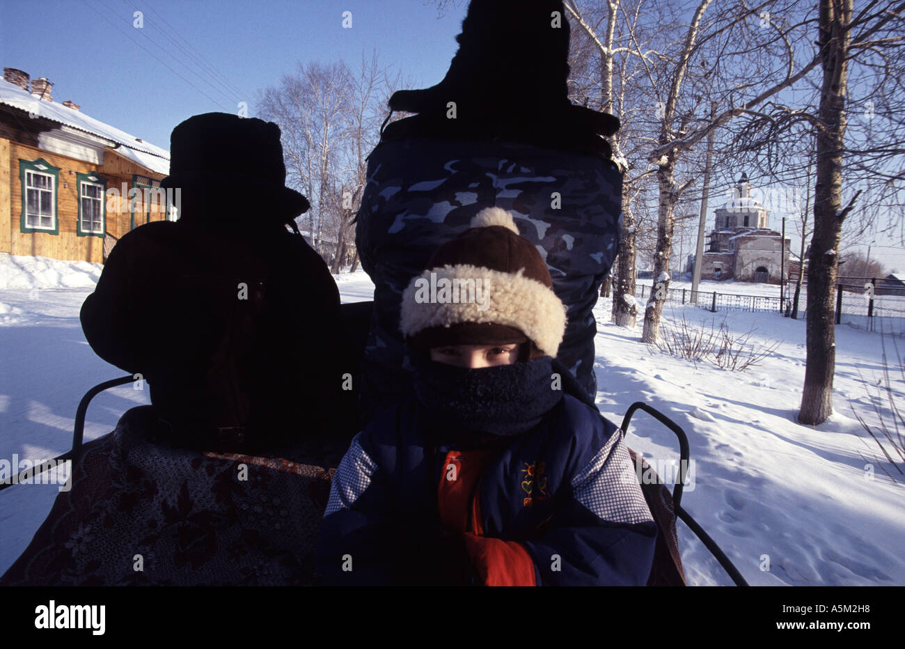 Siberian boy wraps up against the cold, on a horse drawn sledge in ...