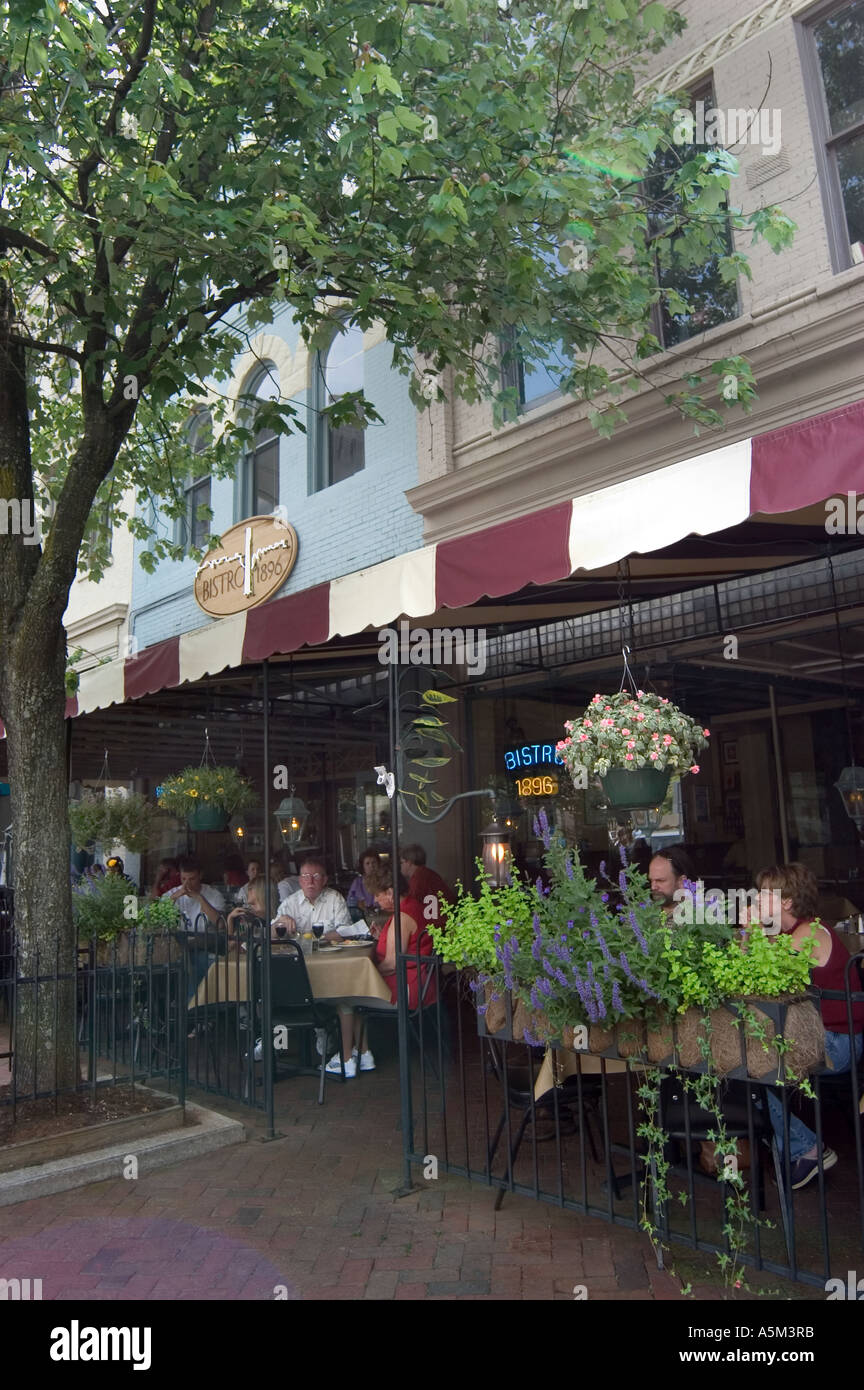 A view of a cobblestone street with an outdoor restaurant and buildings ...