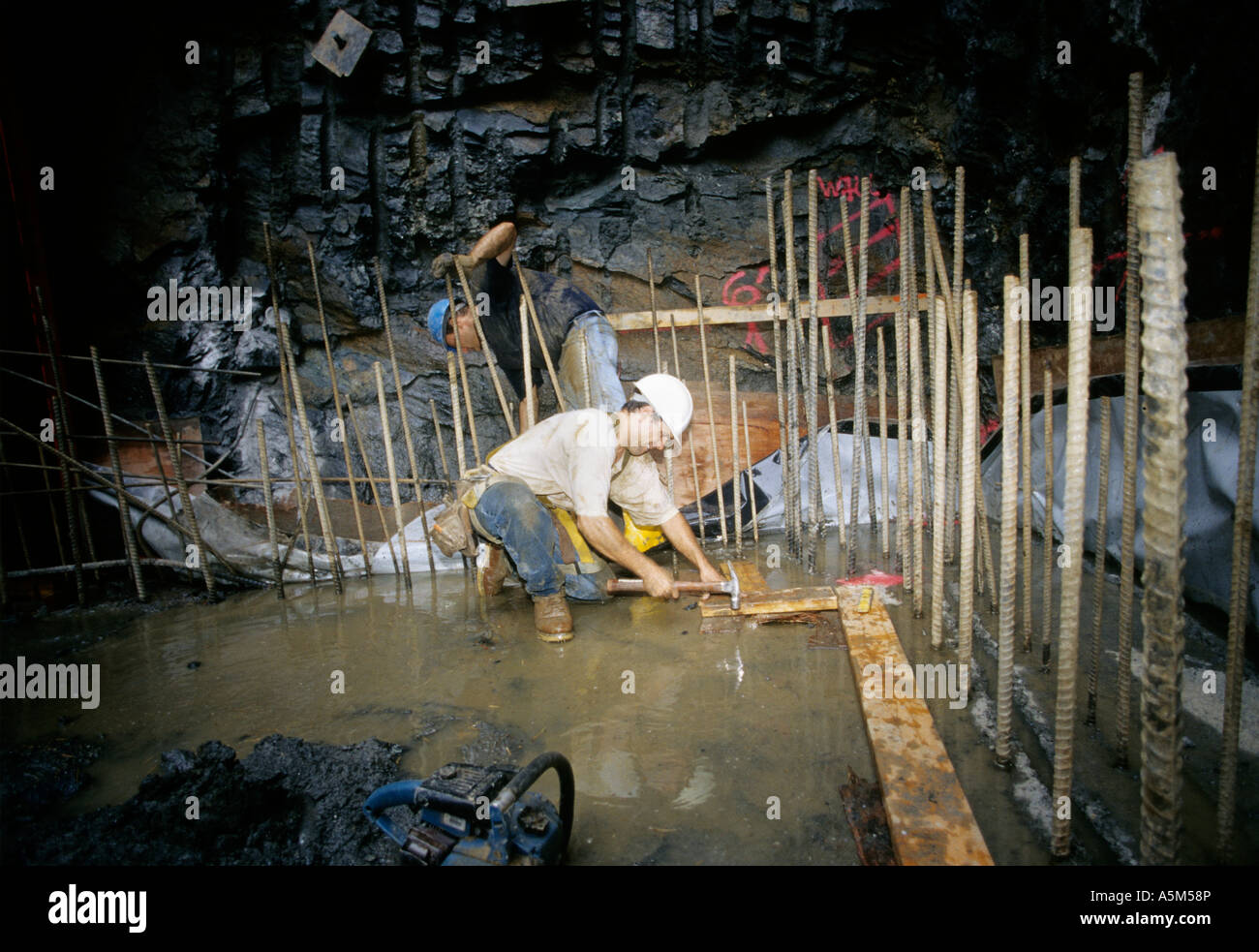Carpenter works in foundation hole of Random House building in New York ...