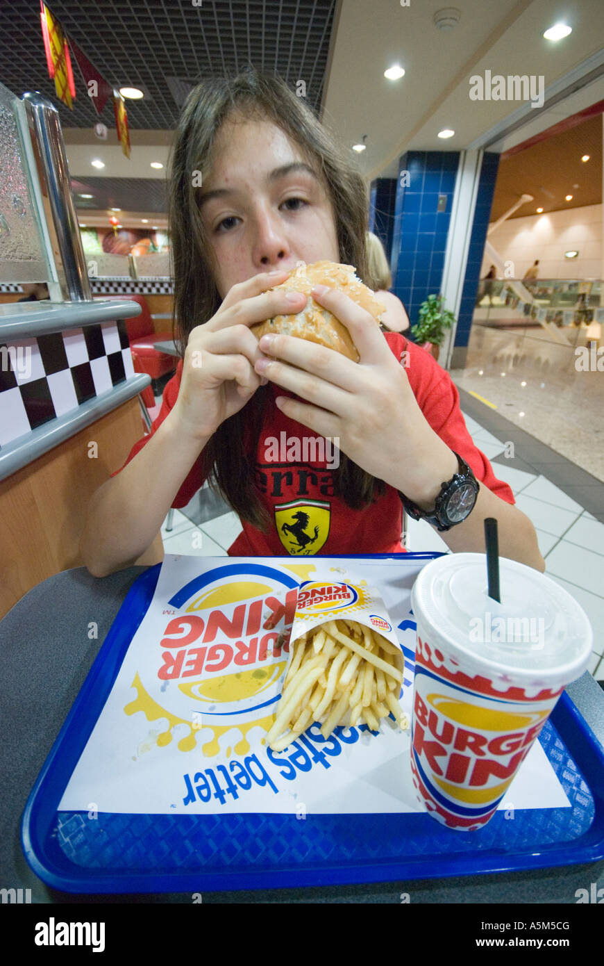 Teenage boy eating a Burger King hamburger Stock Photo - Alamy
