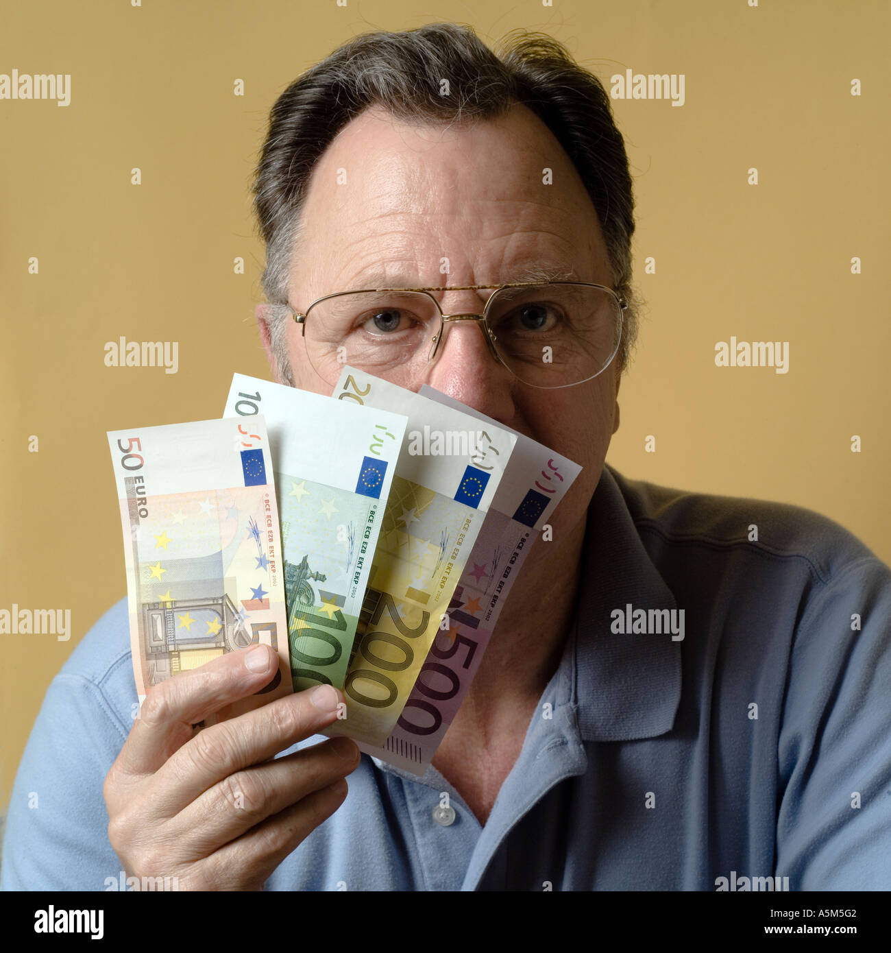 MR MATURE MAN HOLDING EURO BANKNOTES IN FRONT OF HIS FACE Stock Photo ...