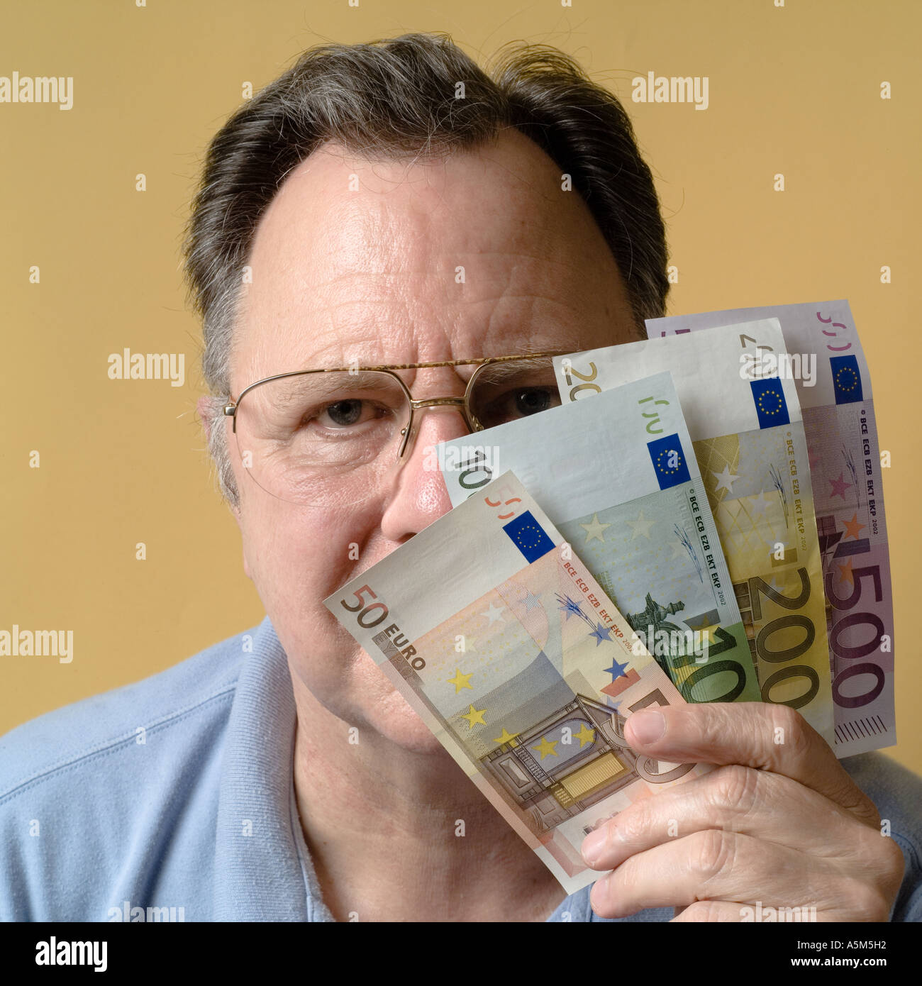 MR MATURE MAN HOLDING EURO BANKNOTES IN FRONT OF HIS FACE Stock Photo ...