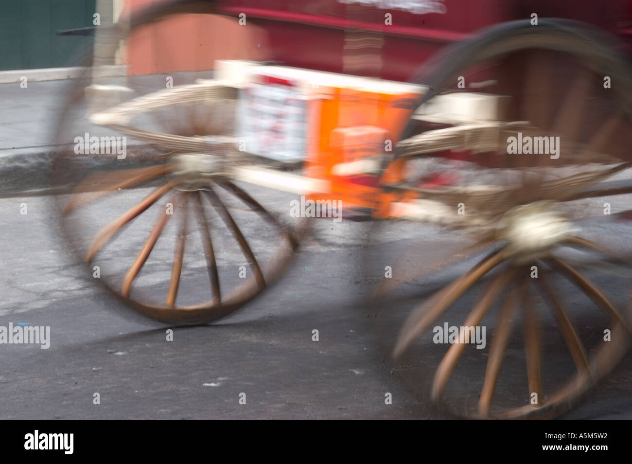 The wheels of a horse and buggy carriage spin in a whirl of motion as ...