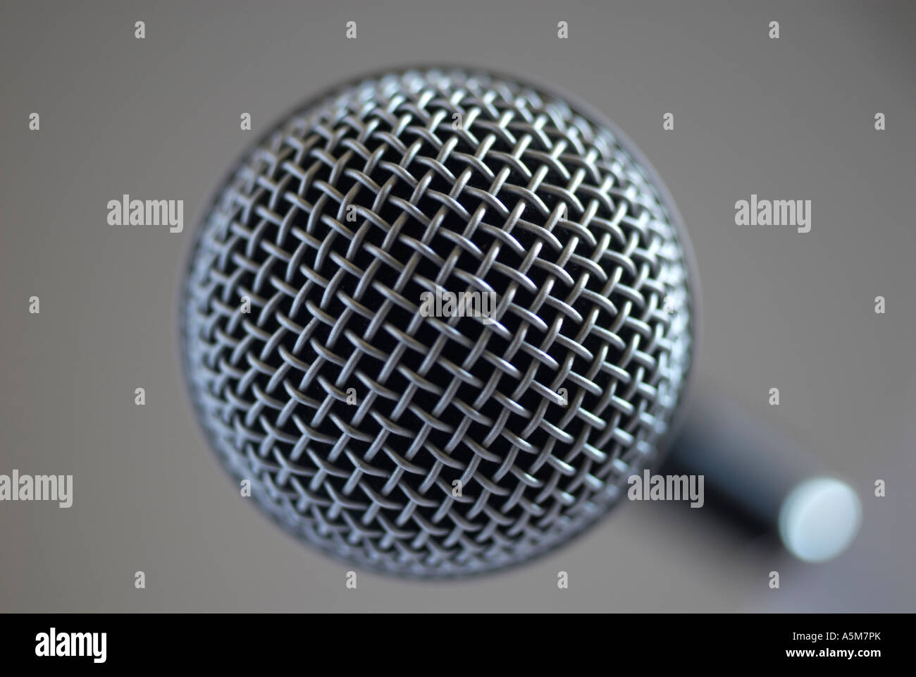 Close up of a microphone on a "grey background Stock Photo - Alamy