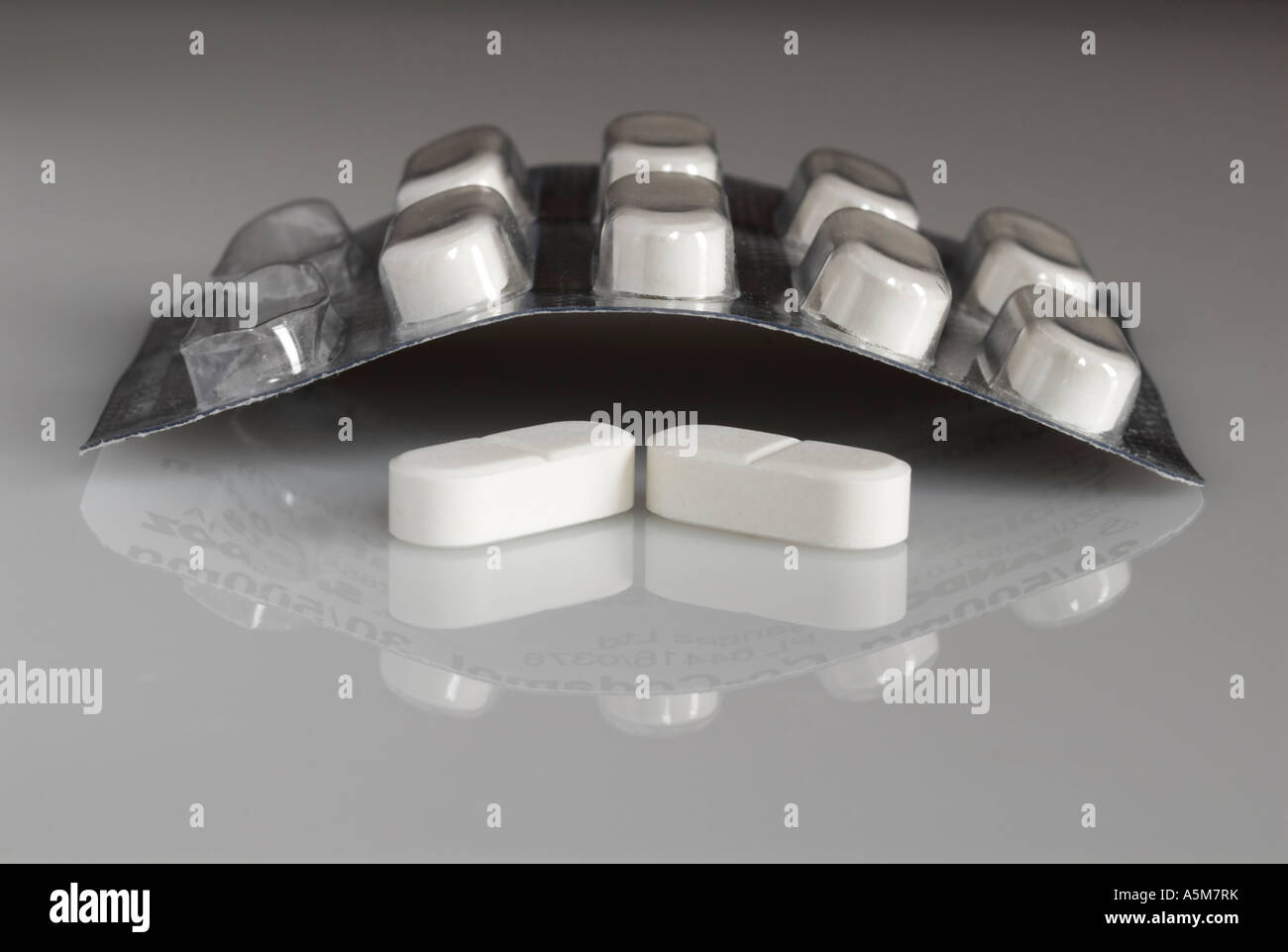 Open packet of tablets on a reflective grey base Stock Photo - Alamy