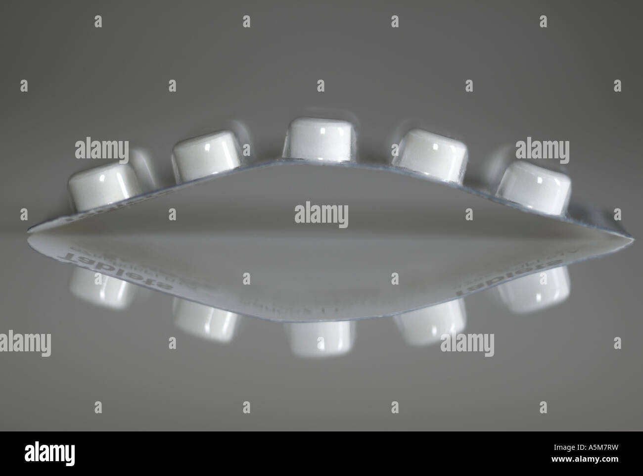 Packet of tablets on a reflective base Stock Photo - Alamy