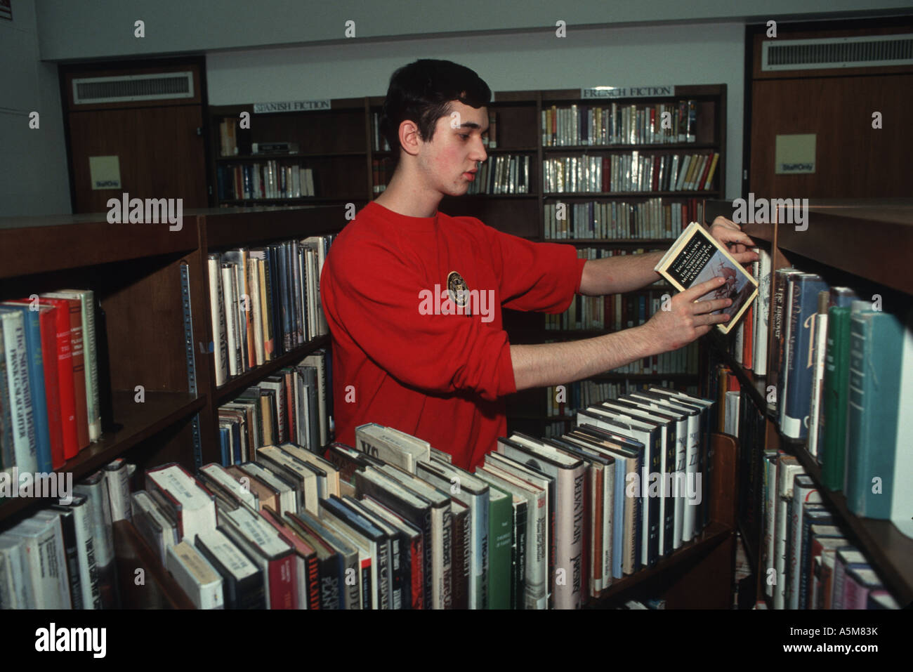 High school student volunteer files books at a New York City public ...