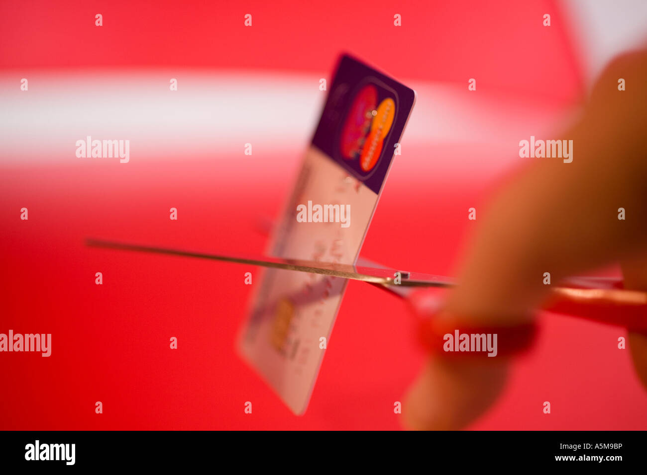 Scissors cutting credit card Stock Photo - Alamy