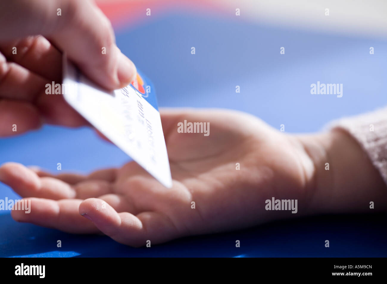 Parent giving a credit card to her child Stock Photo - Alamy
