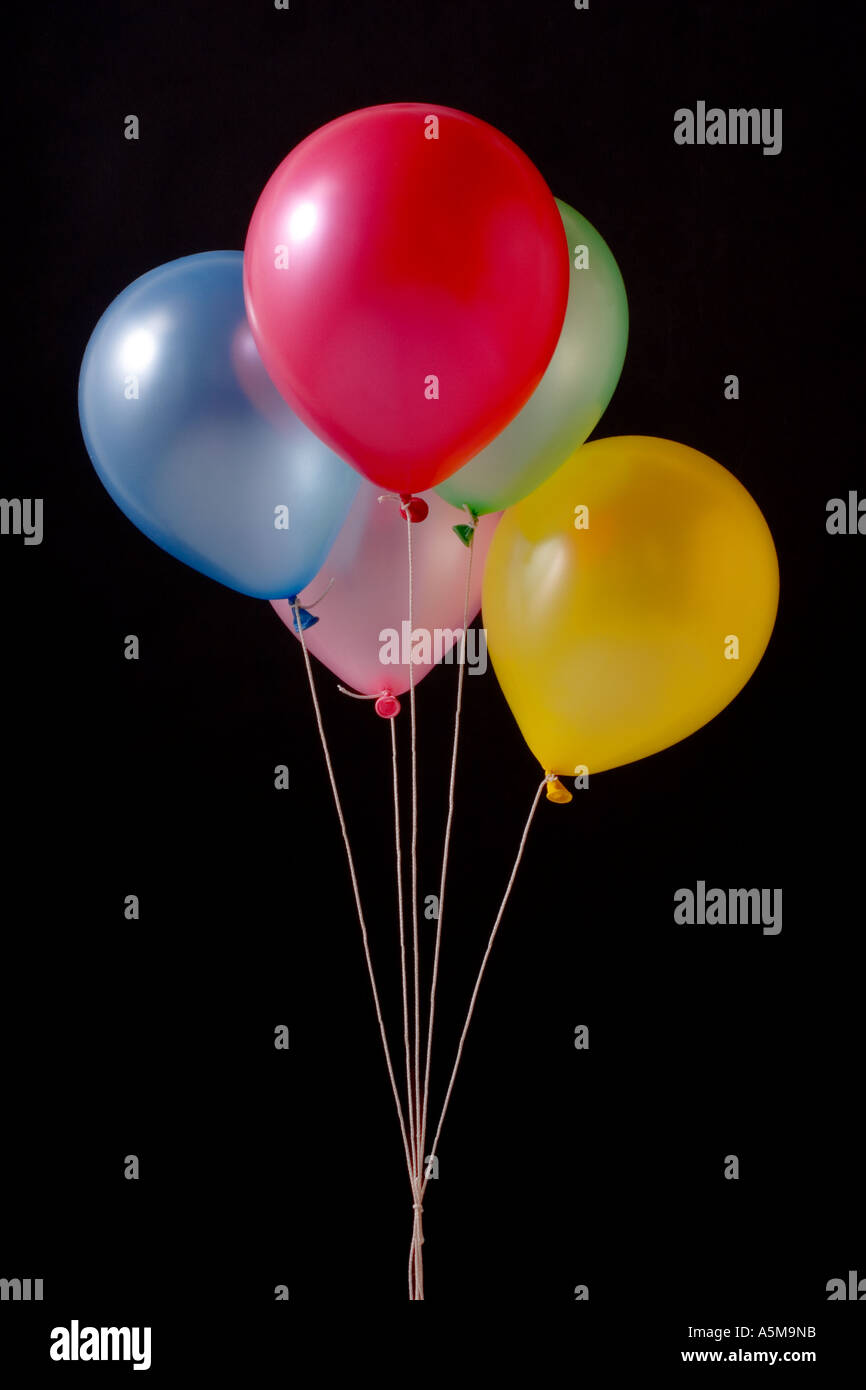 A bunch of colorful balloons against a solid black background Stock ...