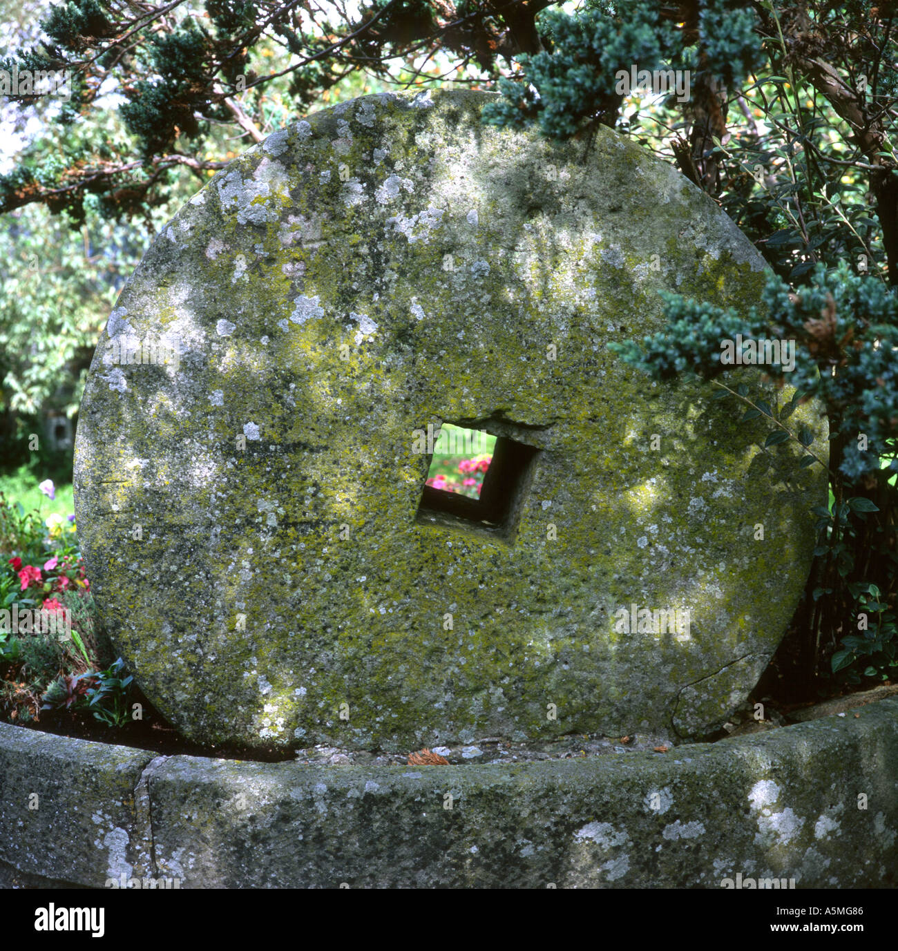 Old mill stone garden feature Stock Photo - Alamy