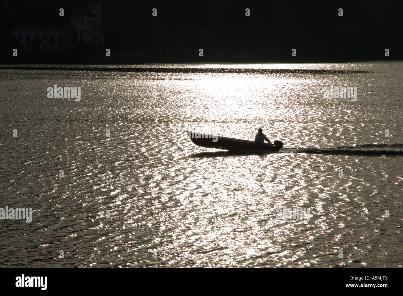 outboard motor boat crossing reflection of sun Stock Photo - Alamy